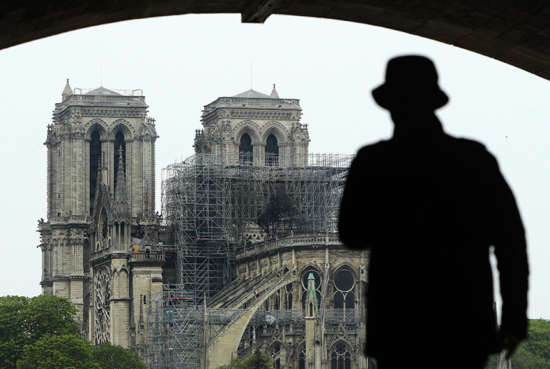 A man looks at the damage caused to Notre-Dame Cathedral following a ...