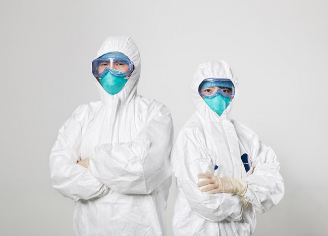 CDC staff standing in front of the white background wall. Photo by Lu ...