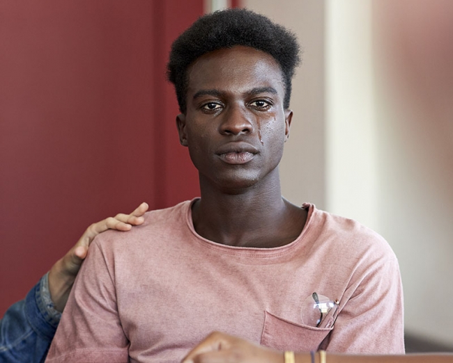 Stock photo Sad young man crying while being consoled by female friends ...