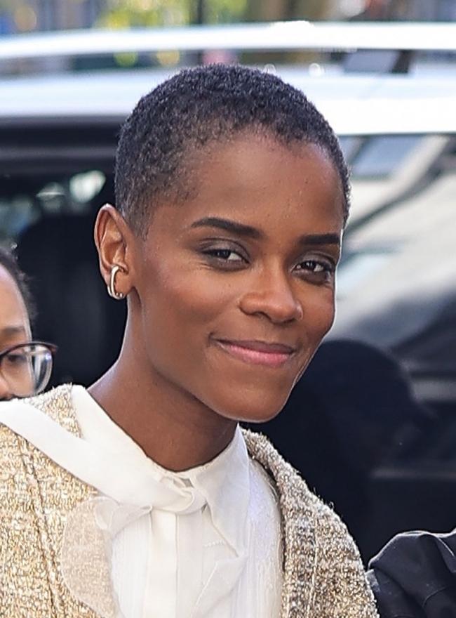 Letitia Wright makes a leggy appearance in the short gold skirt as she ...