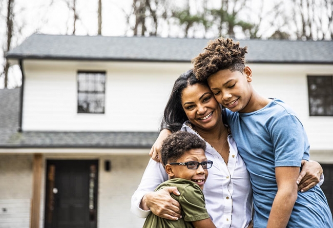 Stock photo – mother and sons in front of residential home. Credit ...