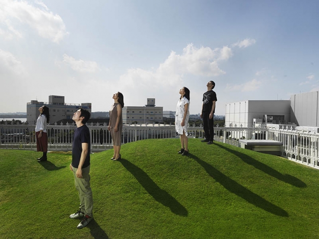 Stock photo - 5 people looking up while standing on a grassy hill ...